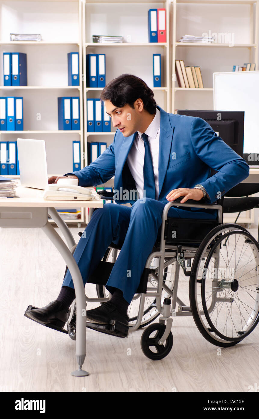 Male employee in wheelchair working at the office Stock Photo - Alamy
