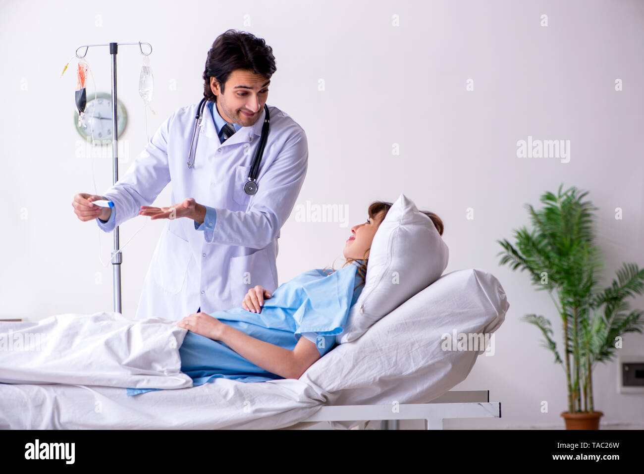 Male doctor visiting female patient in ward Stock Photo - Alamy