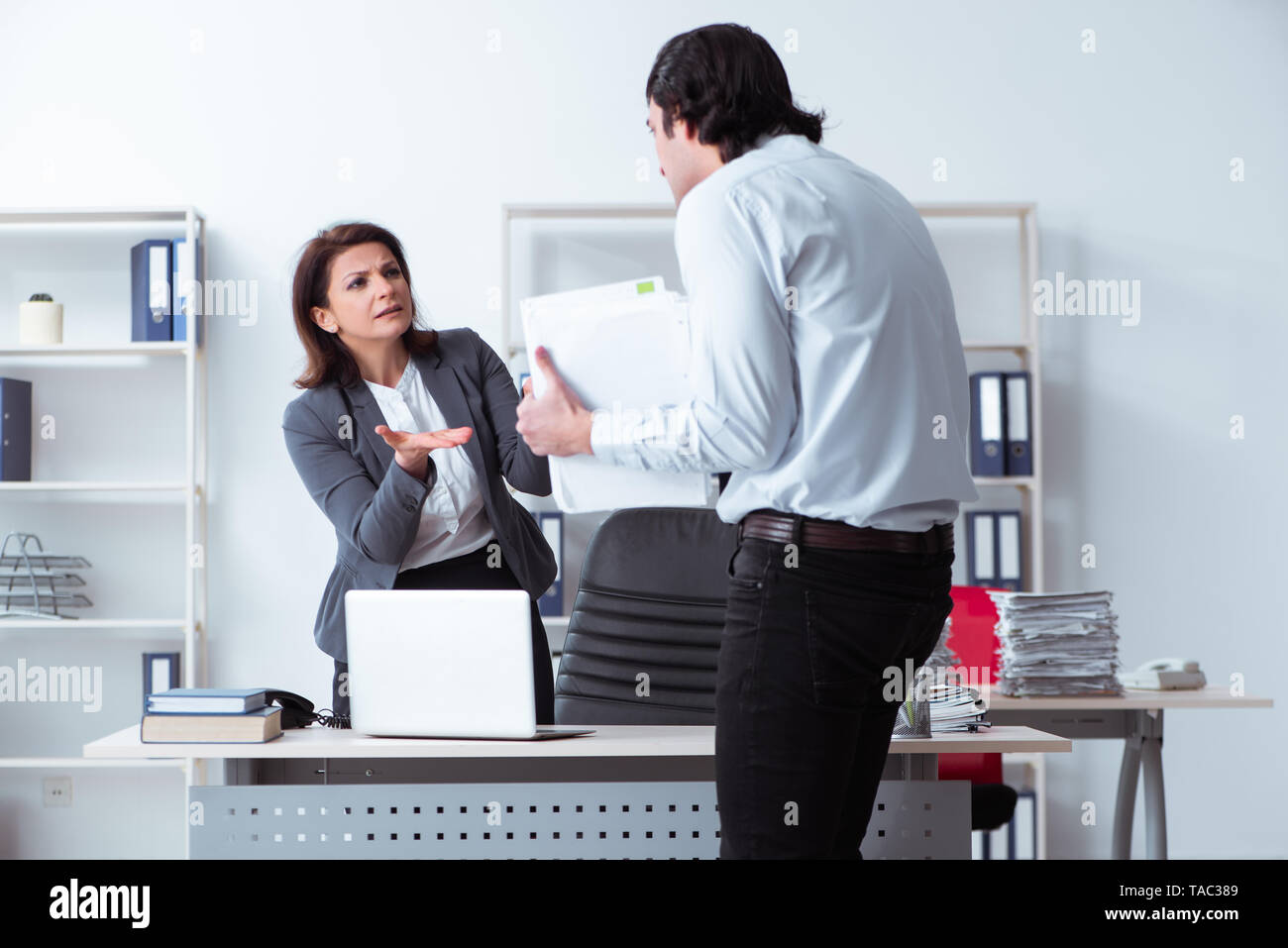 Old female boss and young male employee in the office Stock Photo - Alamy