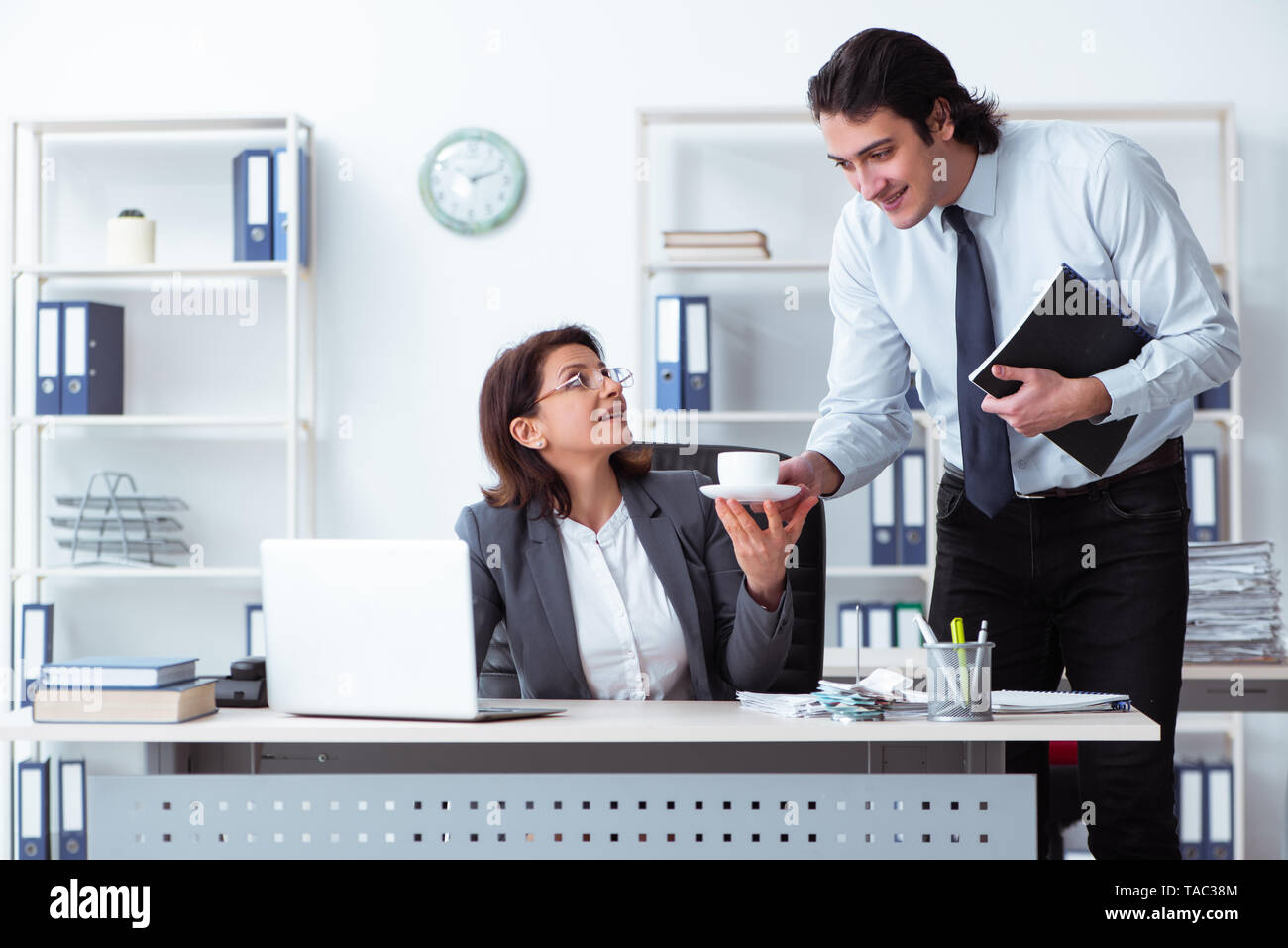 Old female boss and young male employee in the office Stock Photo - Alamy