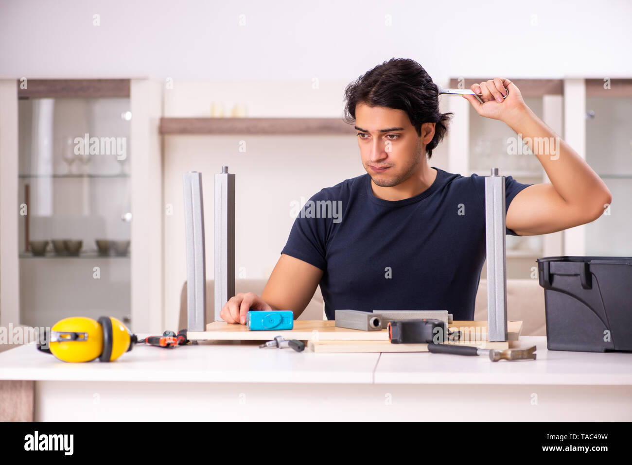 Young man repairing furniture at home Stock Photo - Alamy