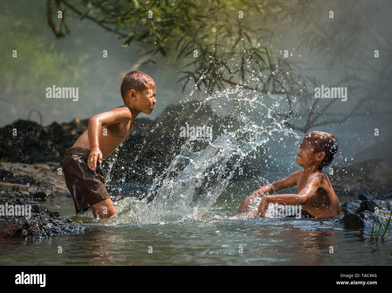 Asia children on river / The boy friend happy funny playing water in ...