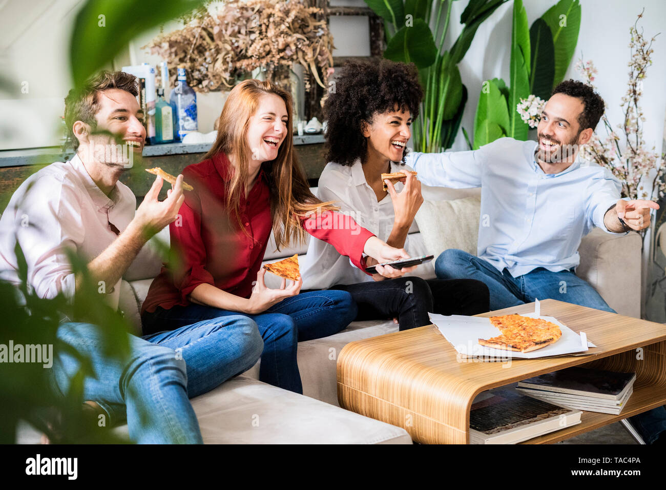 Friends having fun, eating pizza, watching TV Stock Photo - Alamy