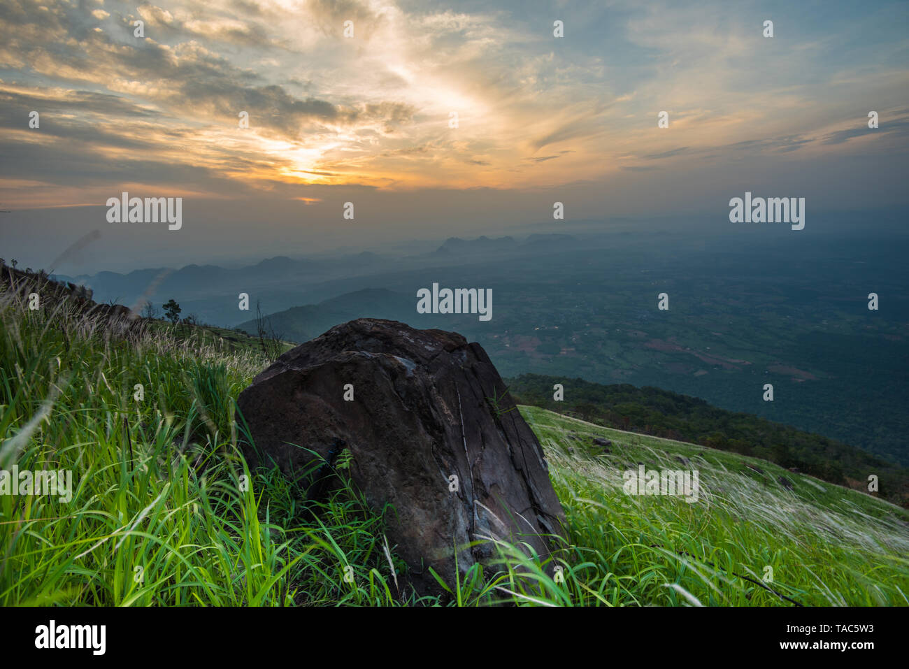 Landscape sunrise on hill mountain with rock stone on green field ...