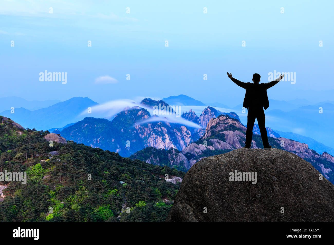 Man standing on top of mountain with arms raised hi-res stock ...