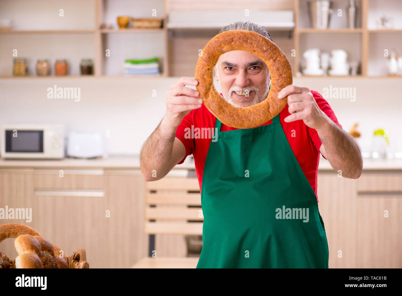 Old male baker working in the kitchen Stock Photo - Alamy