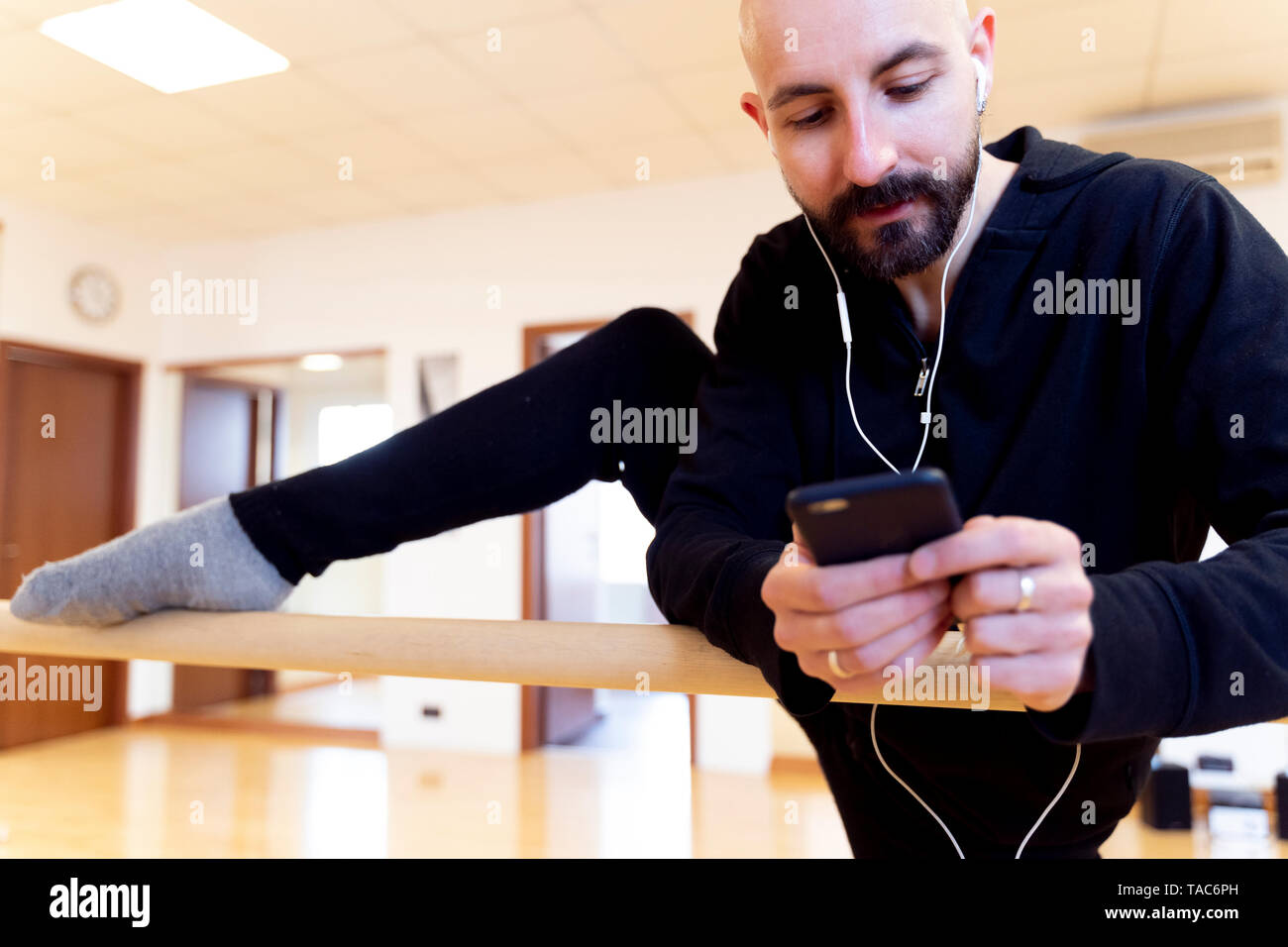 Ballet dancer stretching and using cell phone in ballet studio Stock ...