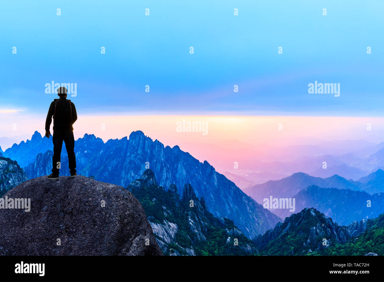 Young happy backpacker on top of a mountain enjoying valley view Stock ...