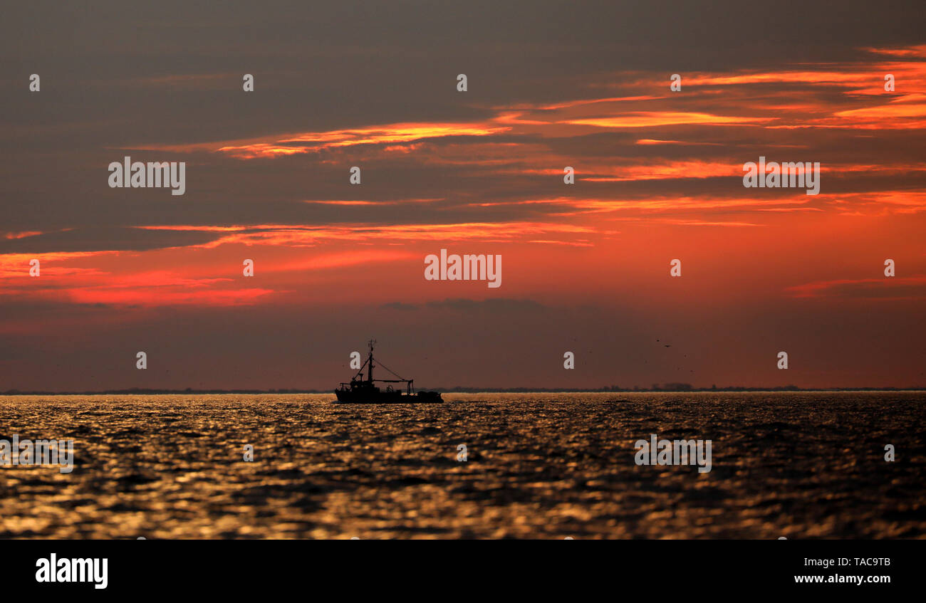 Heacham, UK. 22nd May, 2019. A fishing boat patrols the sea just before ...