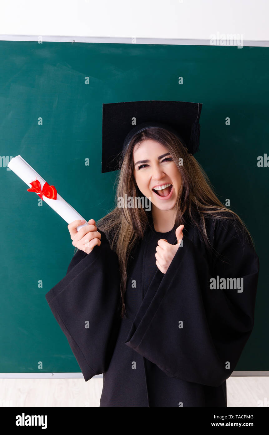 Female graduate student in front of green board Stock Photo - Alamy