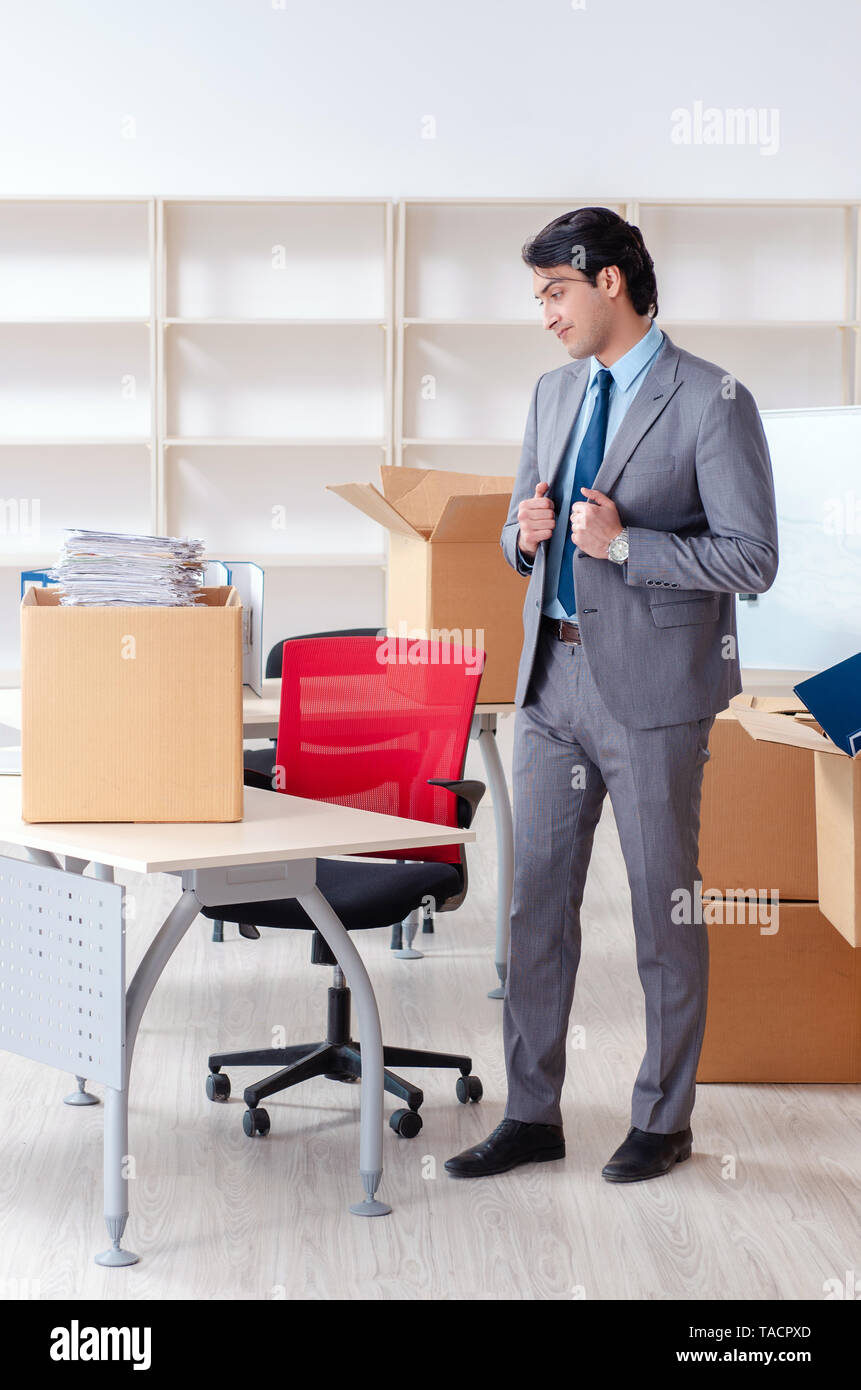 Young man employee with boxes in the office Stock Photo - Alamy