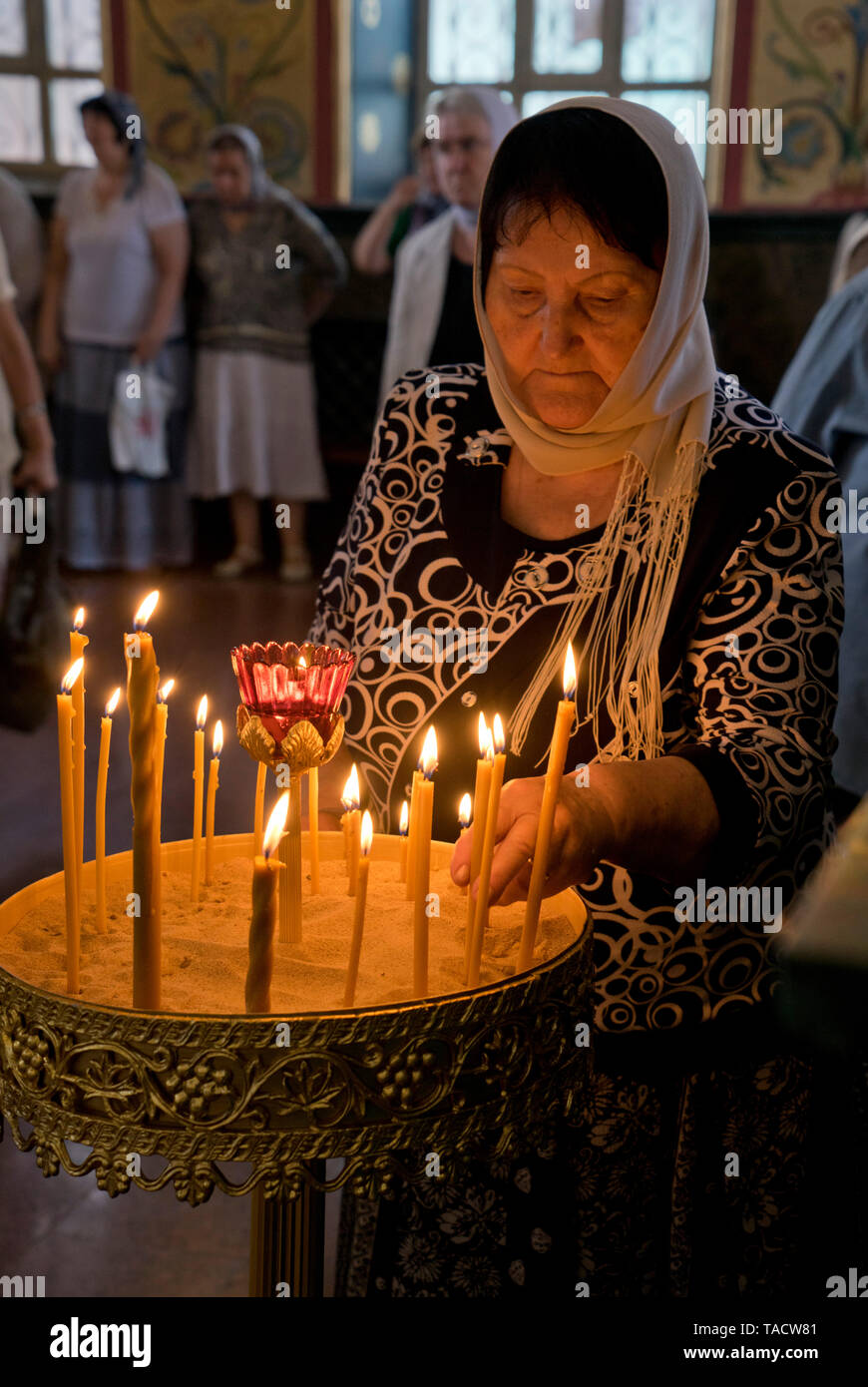 Woman lighting candles at a Russian Orthodox church service in ...