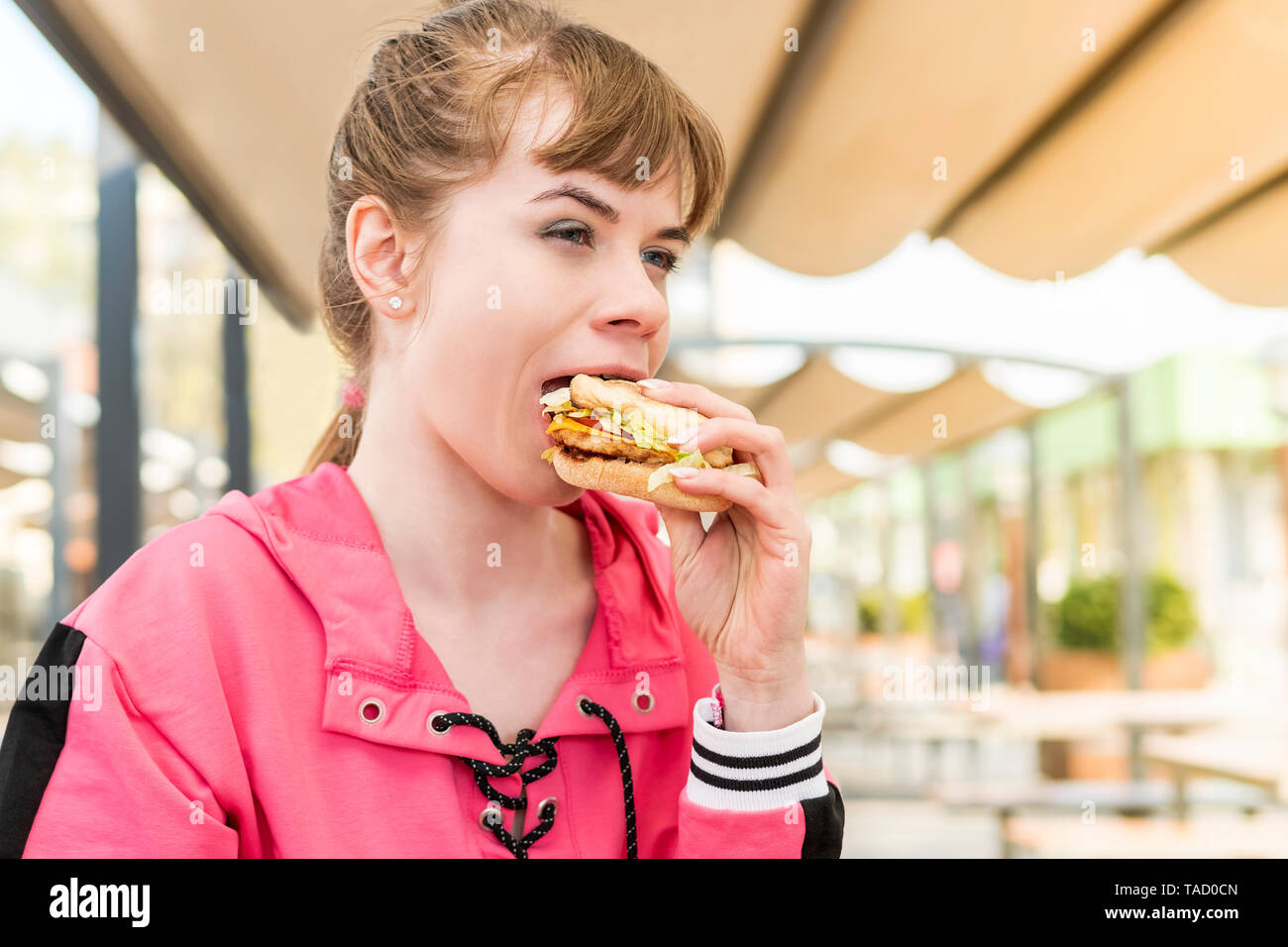 Young woman eating burger model hi-res stock photography and images - Alamy