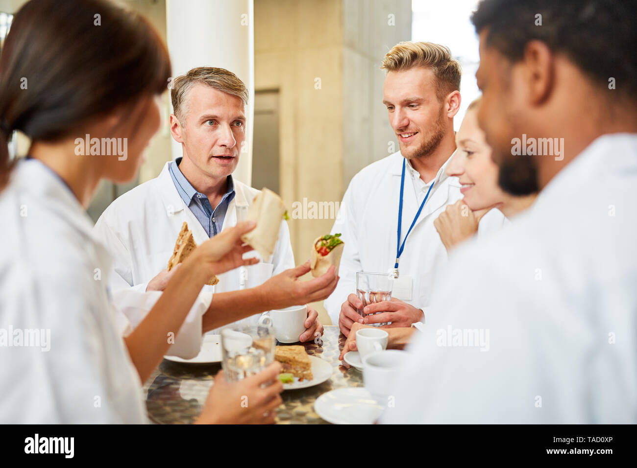 Group of doctors in the cafeteria or canteen eating and relaxing small ...