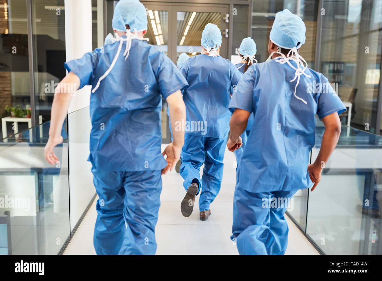Group of surgeons run fast to an emergency in the emergency room in the ...