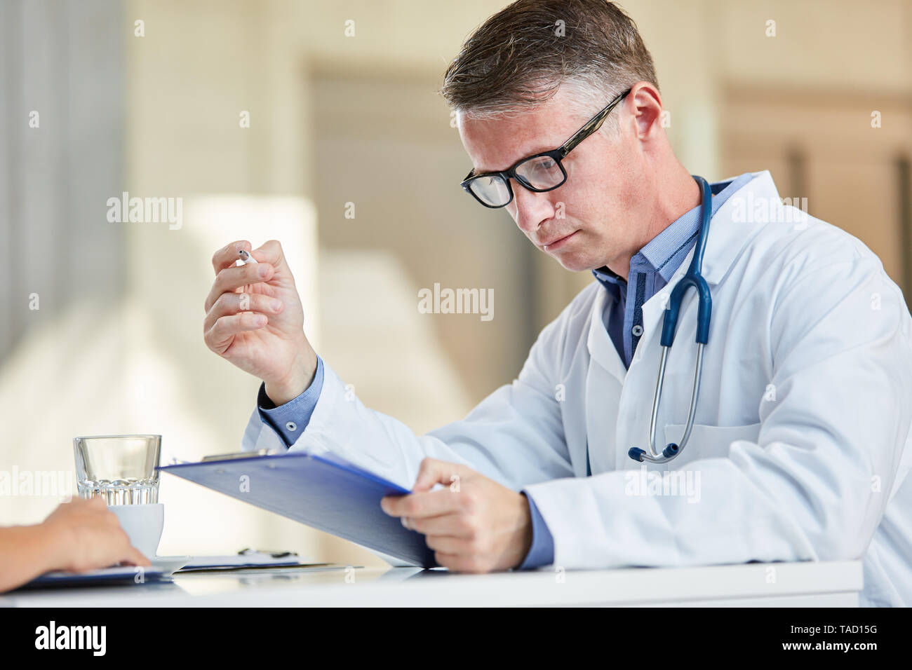 Doctor as a clinic boss in the administration reads a file and does the ...