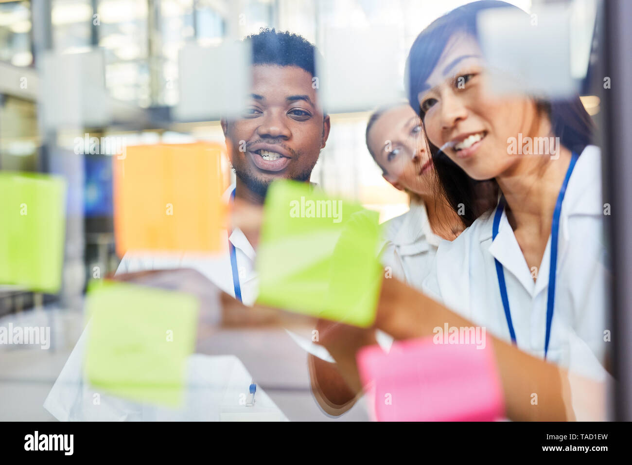 Doctors in a creative brainstorming workshop collect ideas on sticky ...