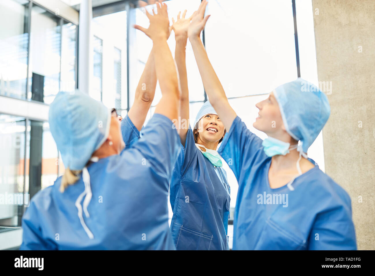 Doctors in the surgery team give themselves a high five for strength ...