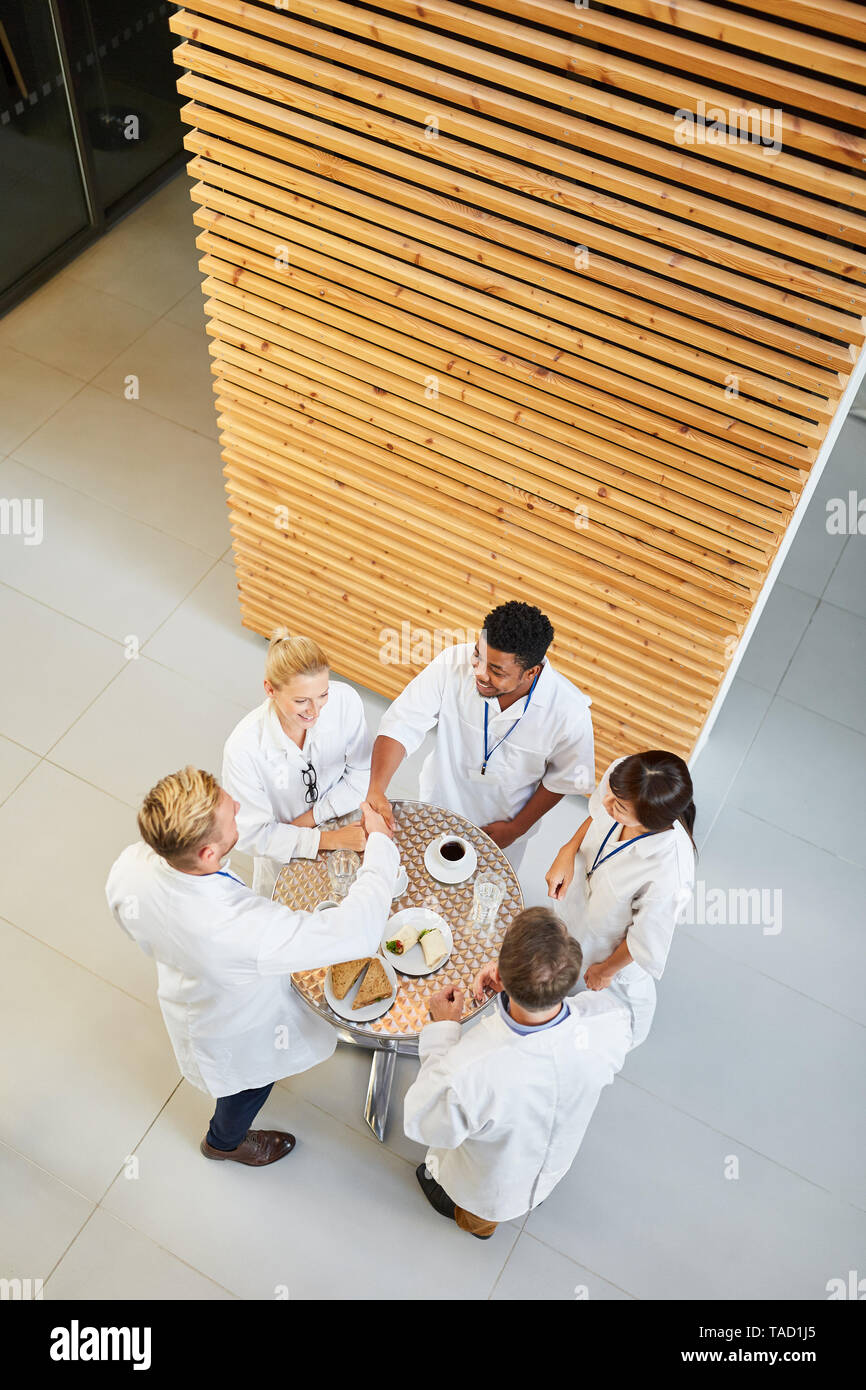 Group of doctors in the cafeteria having a coffee break while having a ...