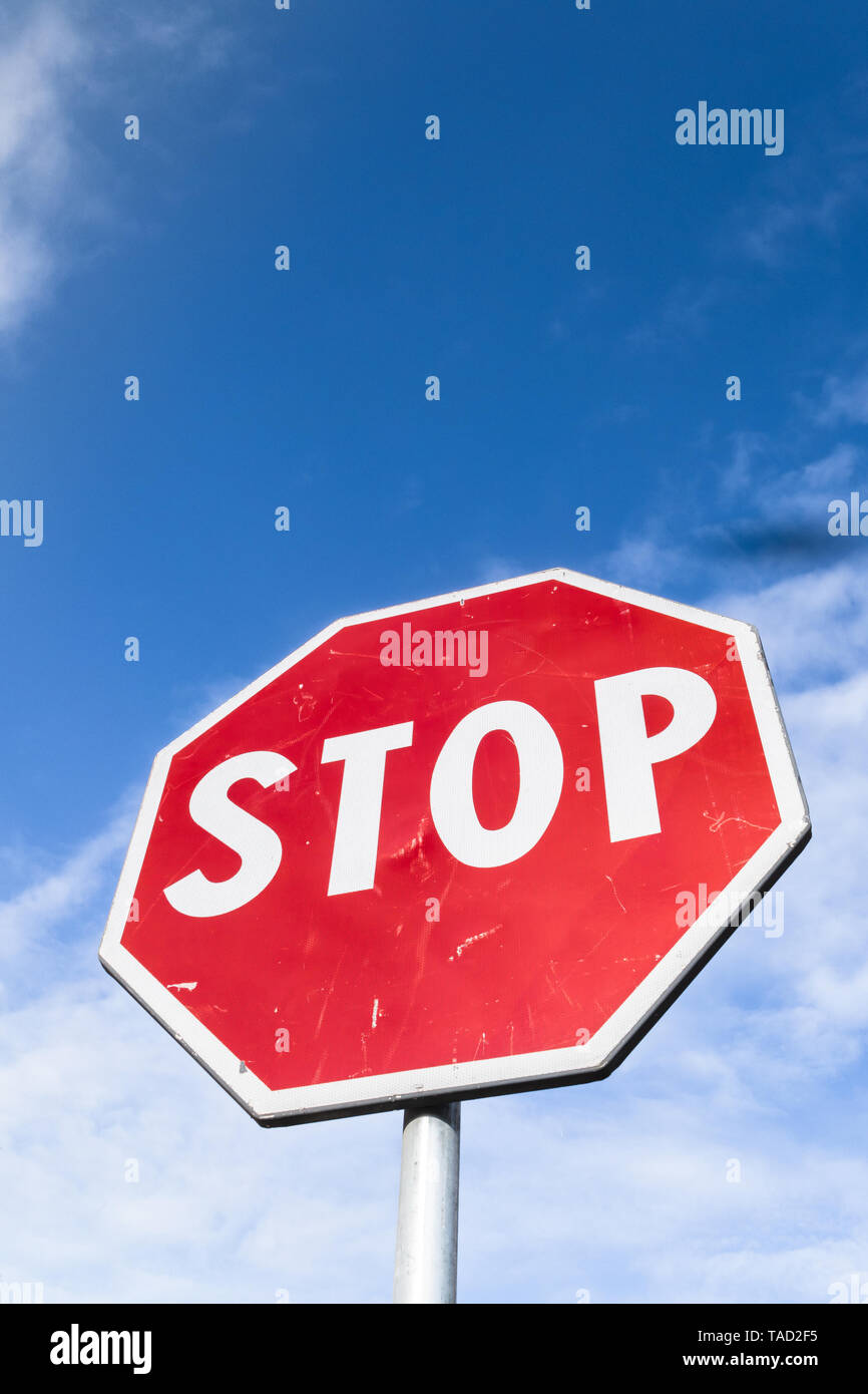 Stop sign against blue sky and white clouds. Bottom view. Space for ...