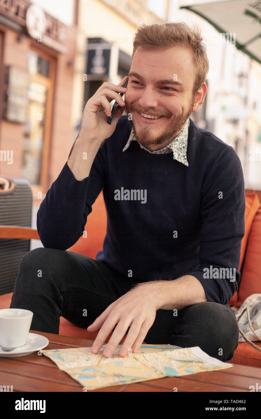 one young man - traveler or tourist talking on a phone, smiling ...