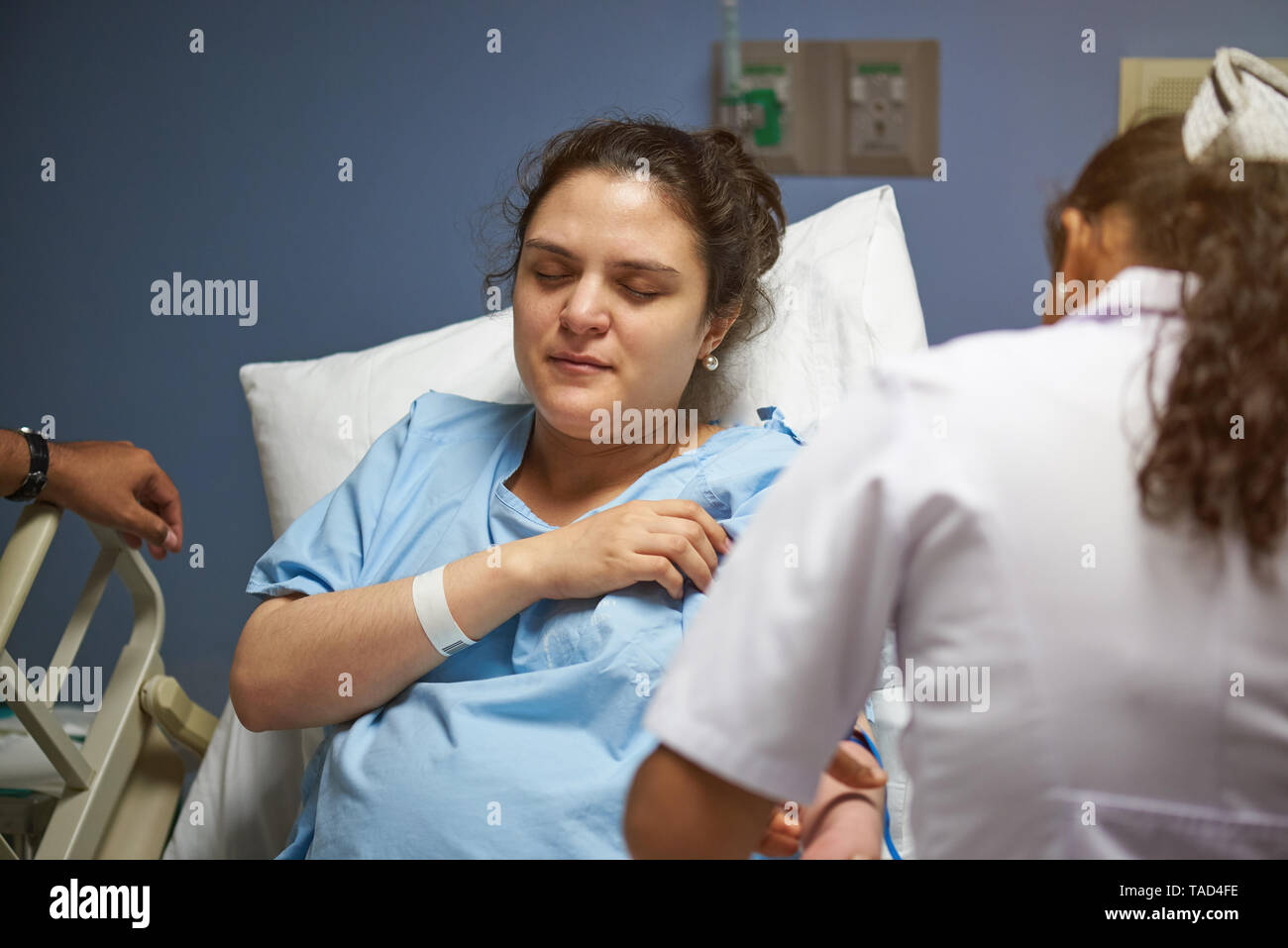 Nurse making procedure to patient in hospital bed Stock Photo - Alamy