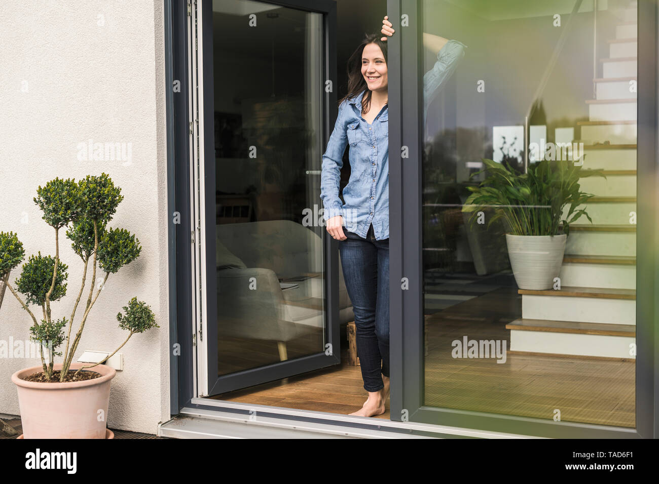 Woman looking around door hi-res stock photography and images - Alamy