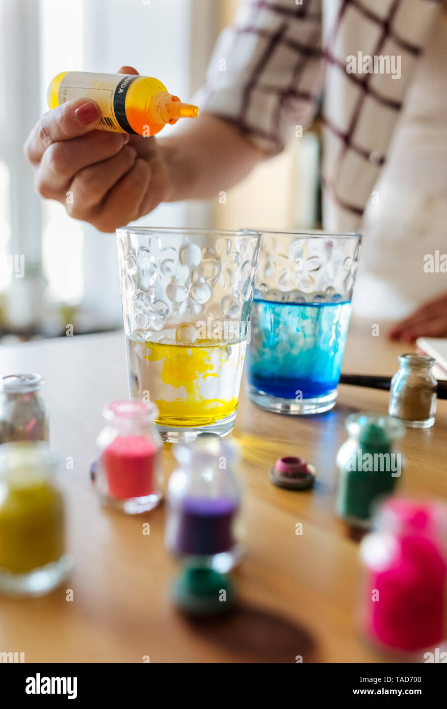 Painter filling liquid colour into glass of water, partial view Stock ...