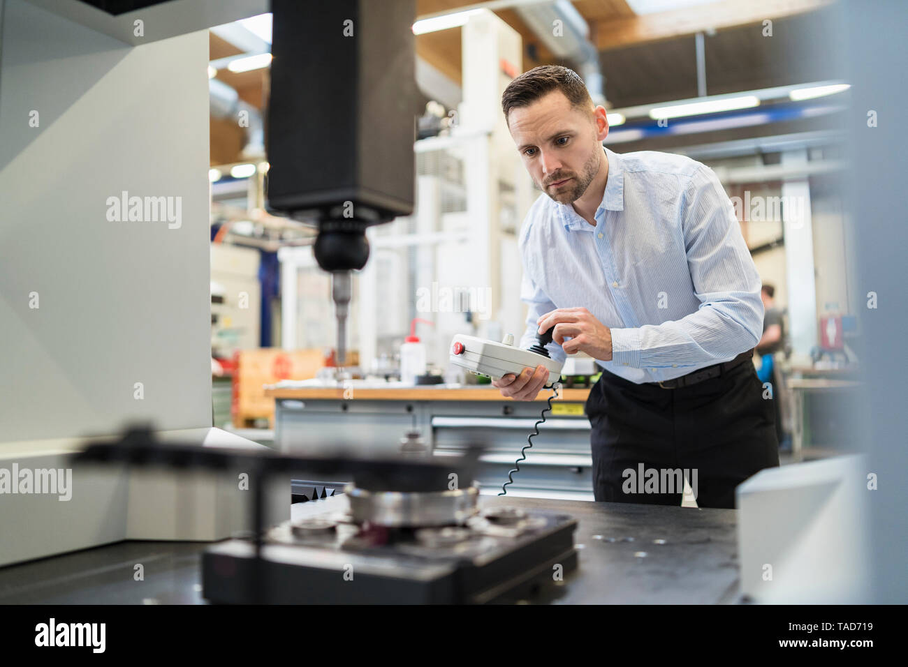 Man operating machine with control in a factory Stock Photo - Alamy
