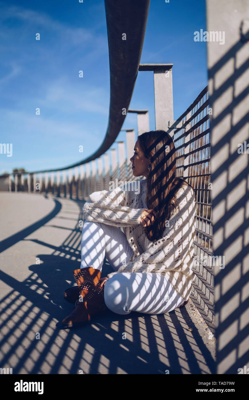 Beautiful young woman sitting on bed working with a laptop and making a ...