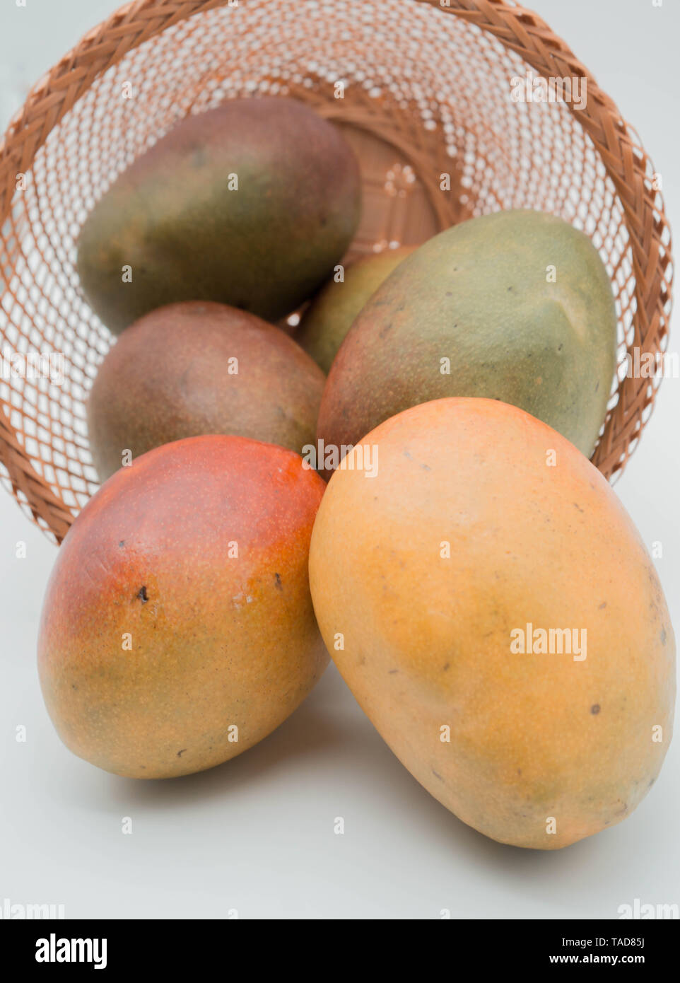 front facing basket with mangoes spilling out Stock Photo - Alamy