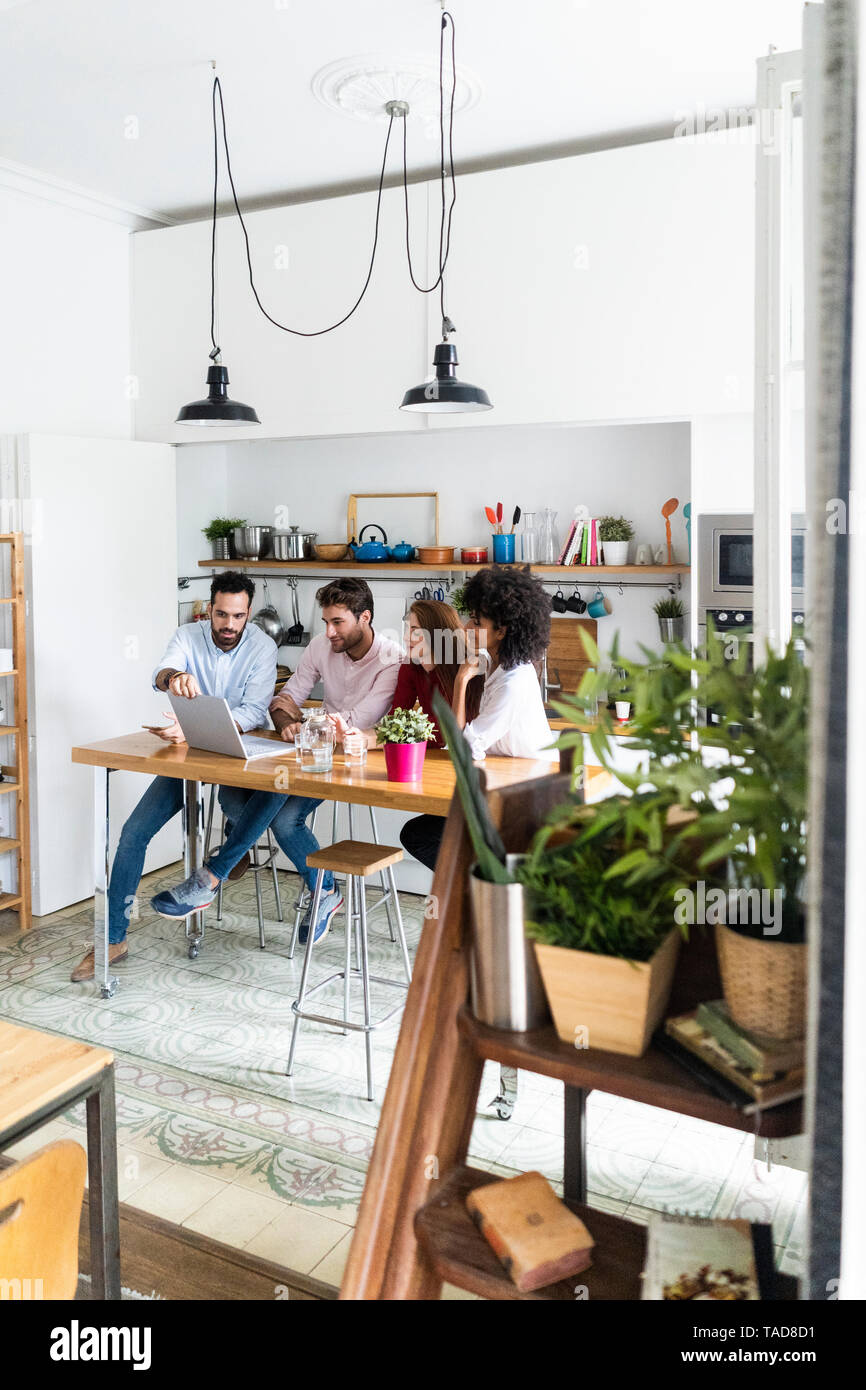 Friends working together on a project in their loft office Stock Photo ...