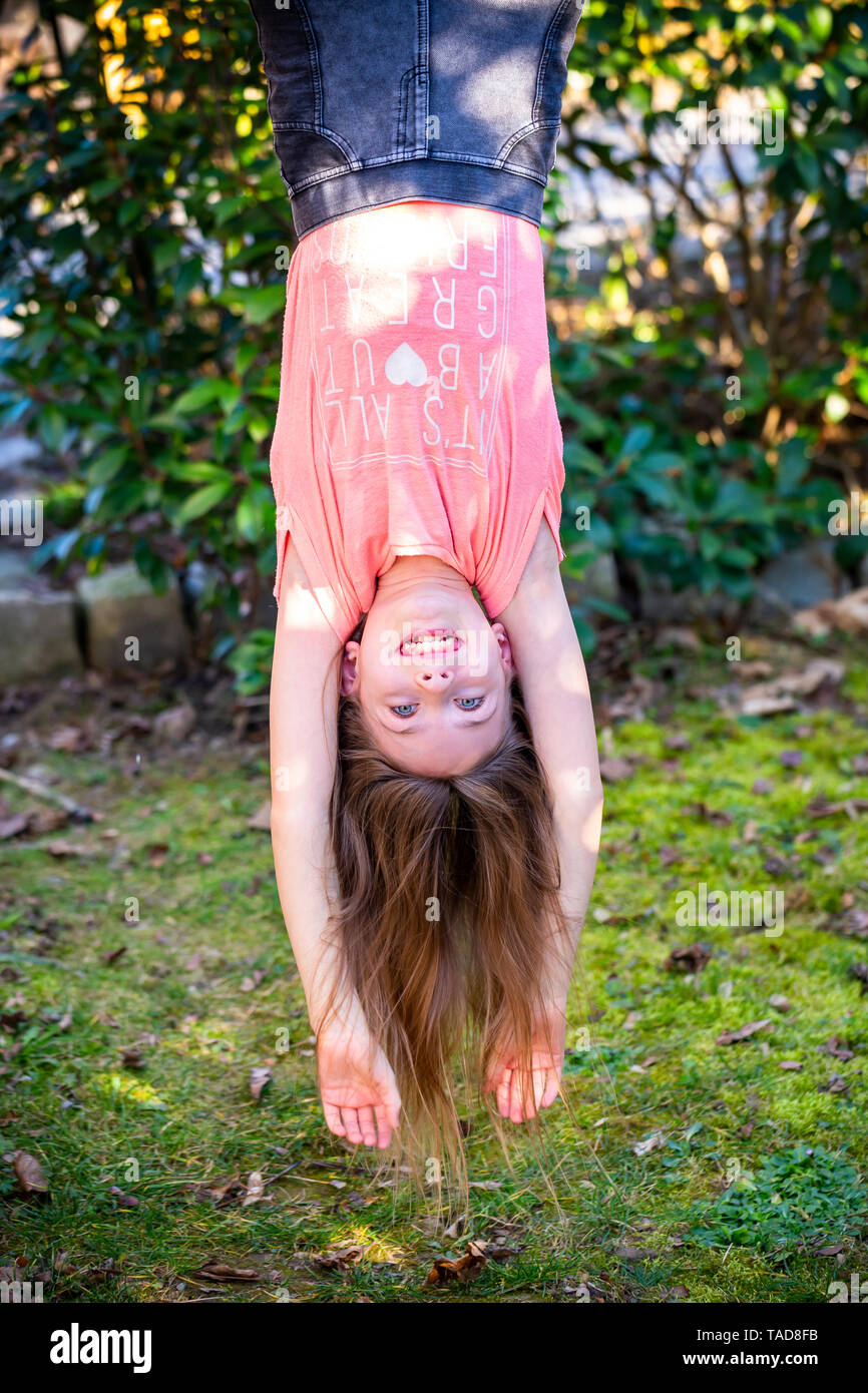 Smiling girl hanging upside down hi-res stock photography and images ...