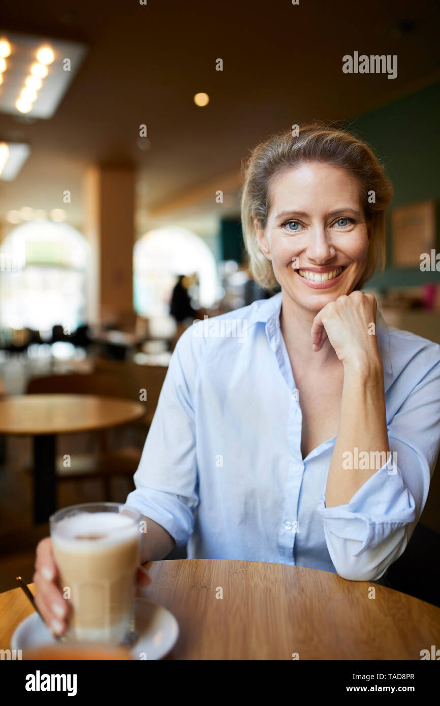 Portrait of smiling woman in a cafe Stock Photo - Alamy