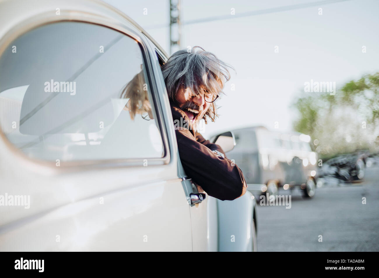 Senior man leaning out of window of vintage car screaming Stock Photo ...