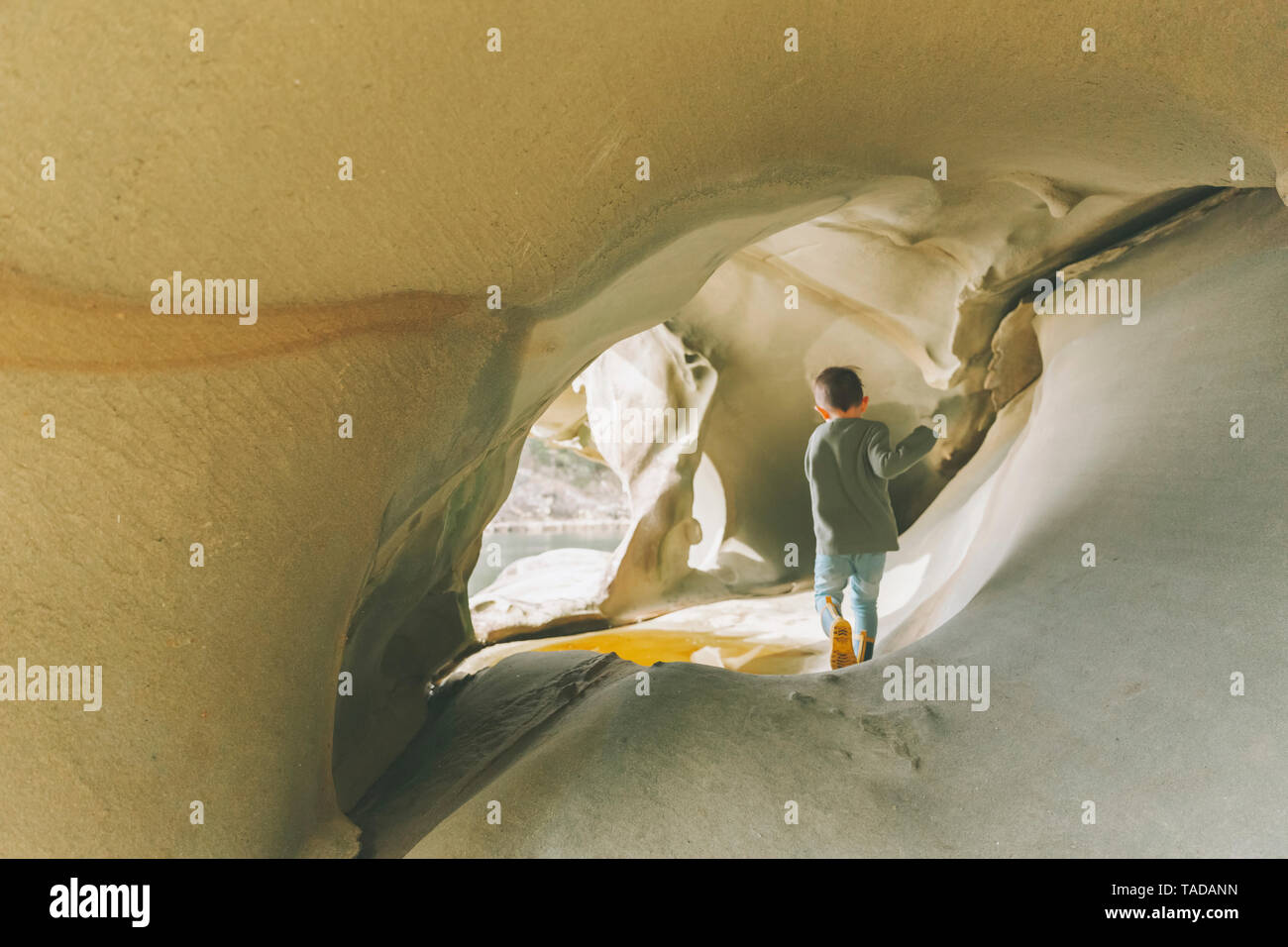 Little boy exploring sandstone caves Stock Photo - Alamy
