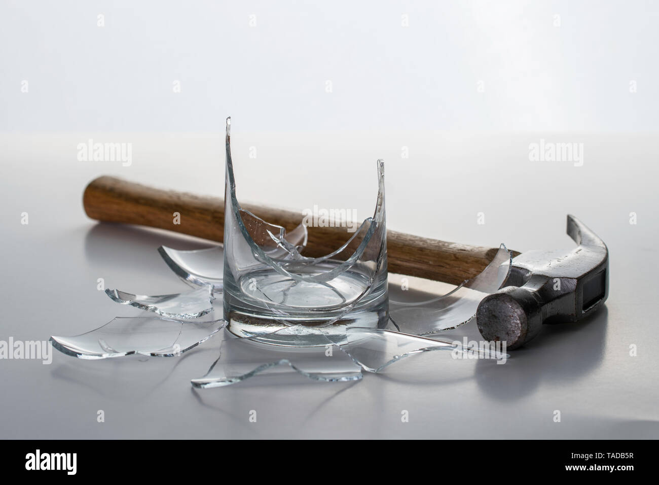 Broken Drinking Glass with hammer and shattered pieces on white ...