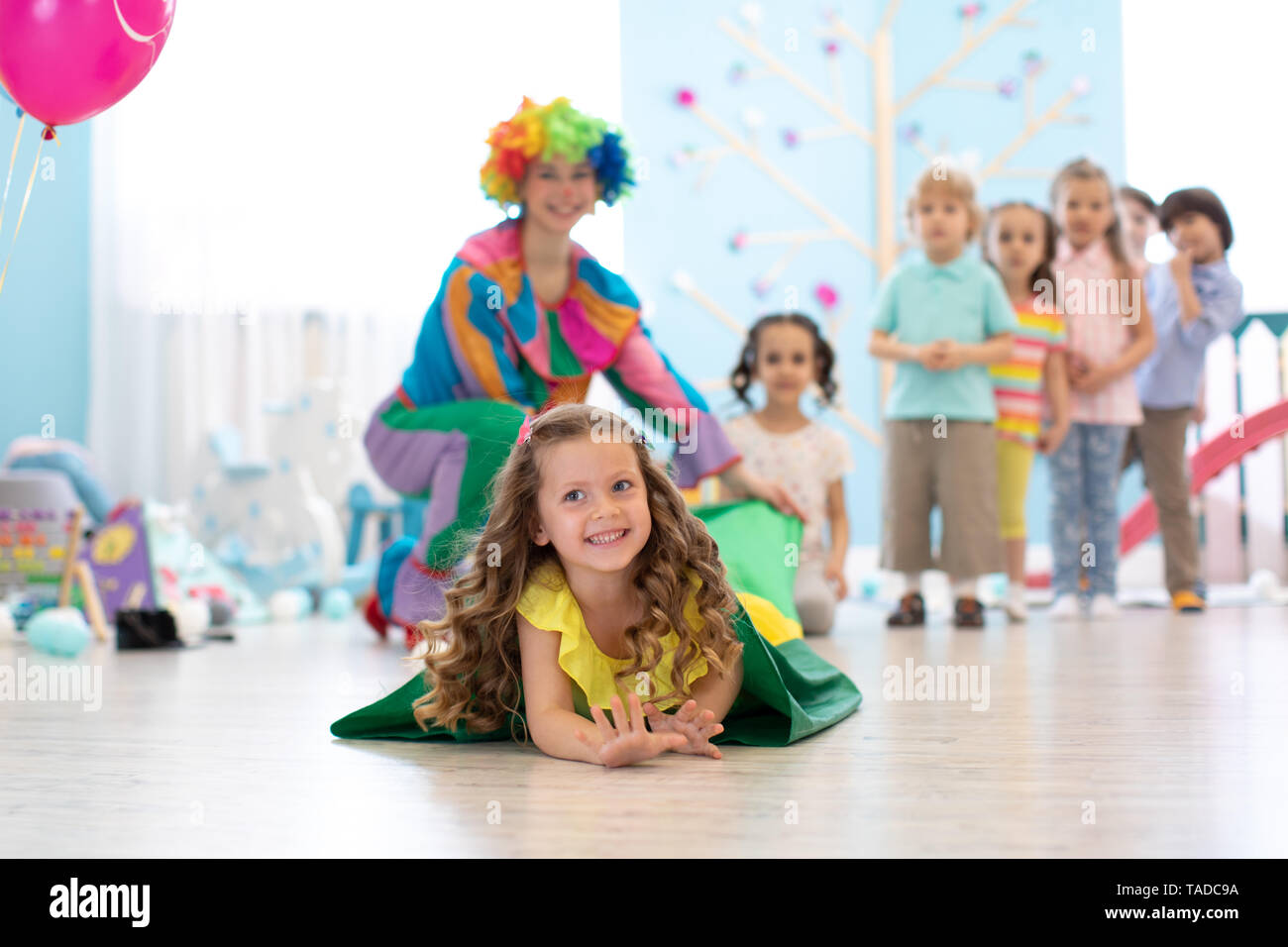 Happy children playing in childrens playroom for birthday party or ...