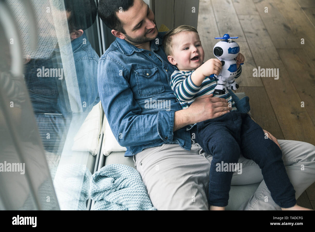 Father and son playing with a toy robot at home Stock Photo - Alamy