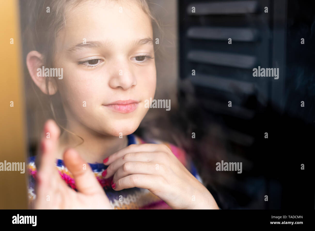 Portrait of girl looking out of window Stock Photo - Alamy