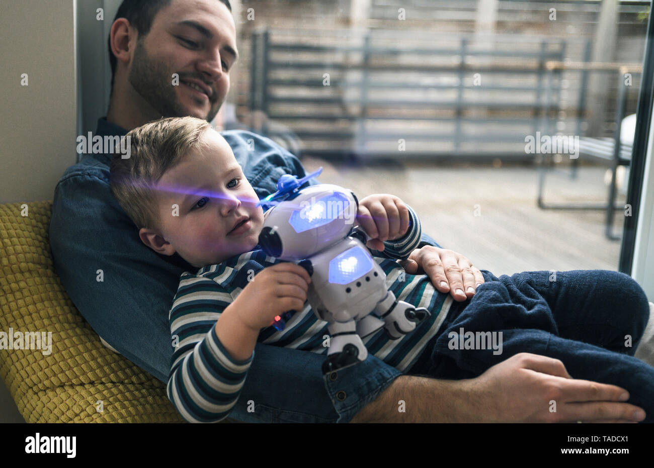 Father and son playing with a toy robot at home Stock Photo - Alamy