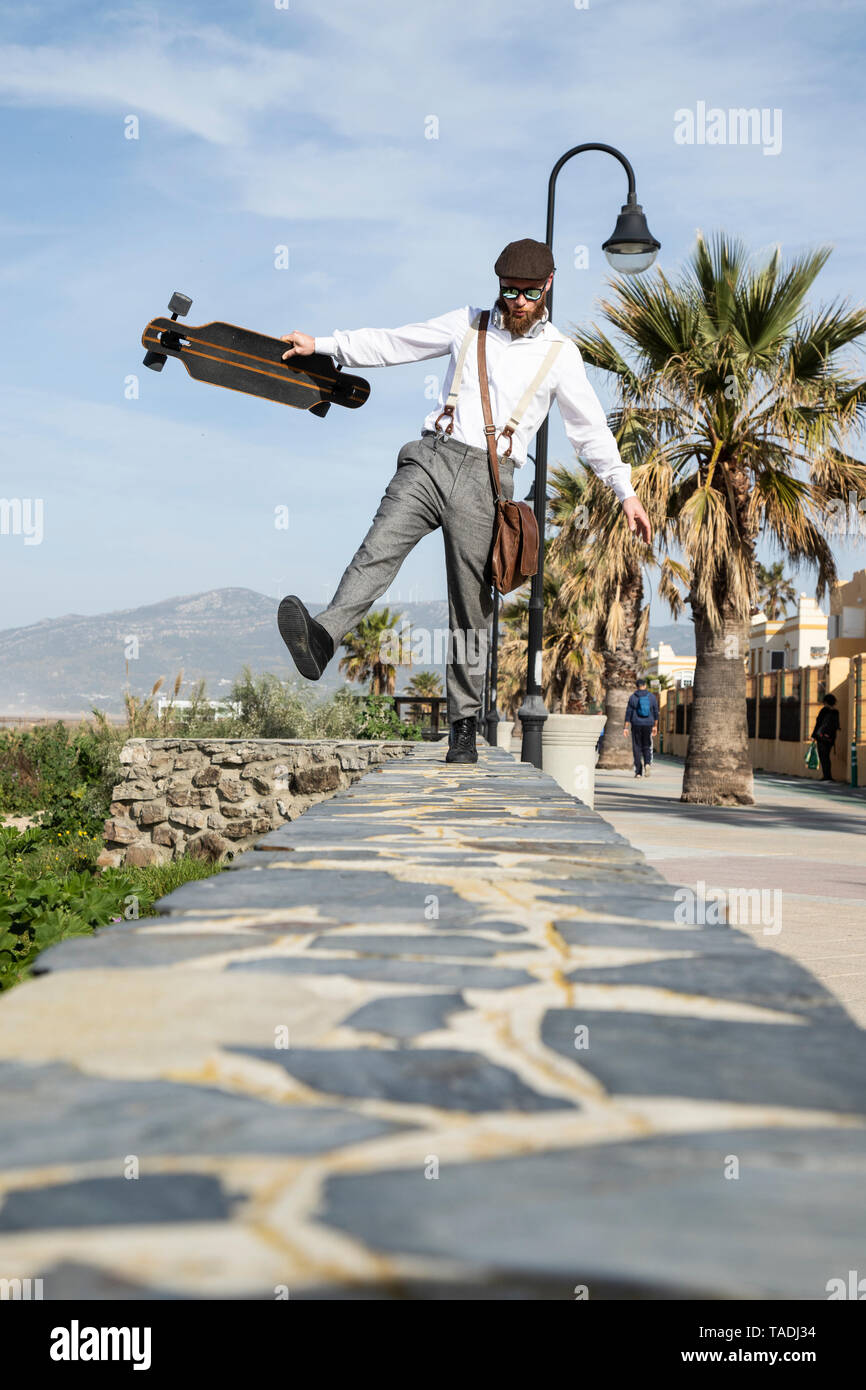 Man with longboard balancing on a wall Stock Photo - Alamy