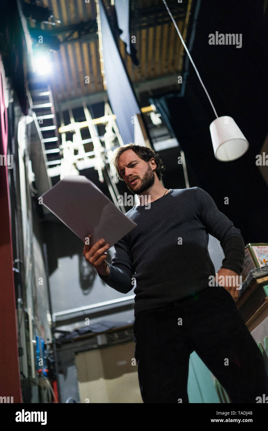 Actor with script rehearsing backstage Stock Photo - Alamy