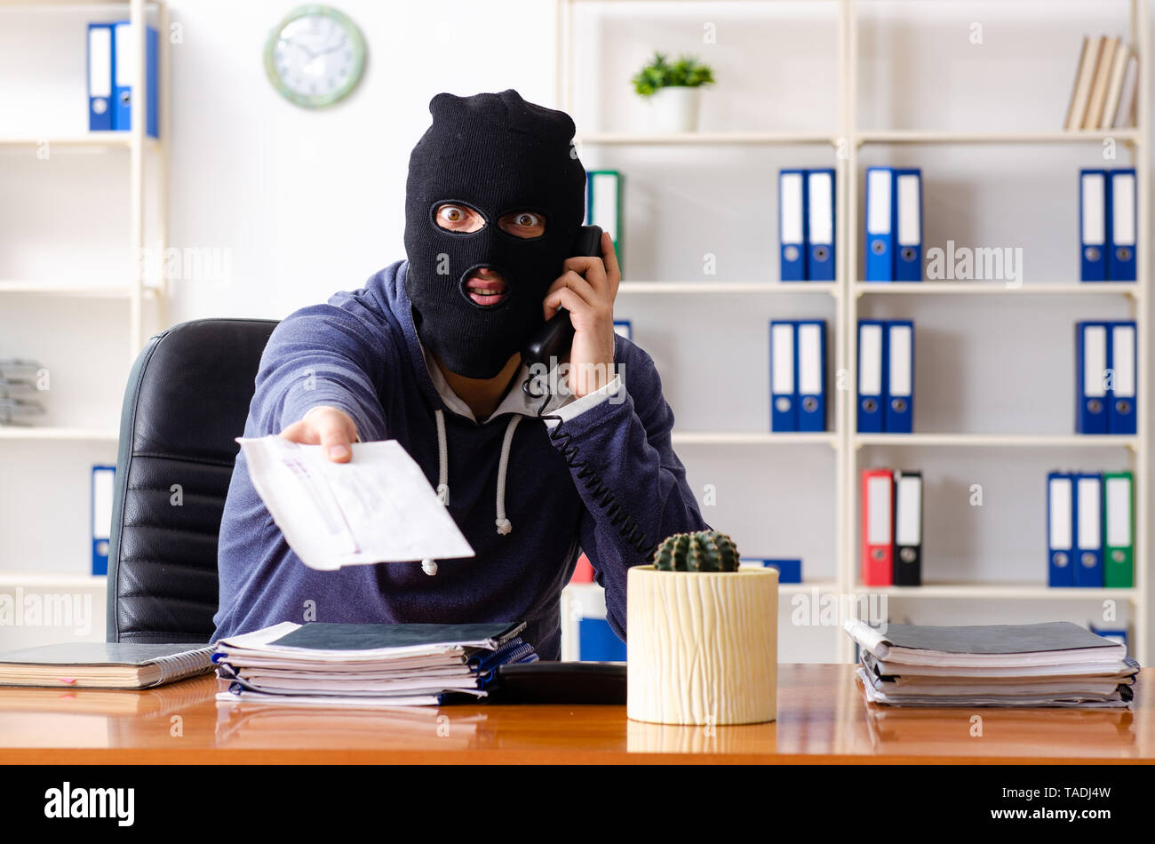 Male thief in balaclava in the office Stock Photo - Alamy