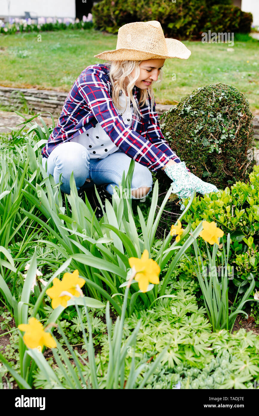 Young woman with a straw hat weeding weeds Stock Photo - Alamy