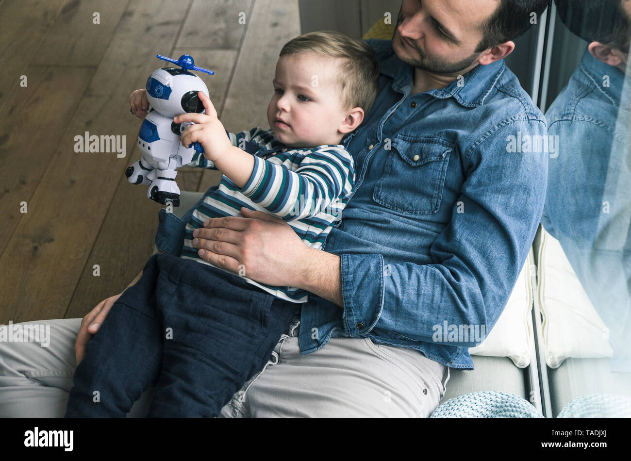 Father and son playing with a toy robot at home Stock Photo - Alamy