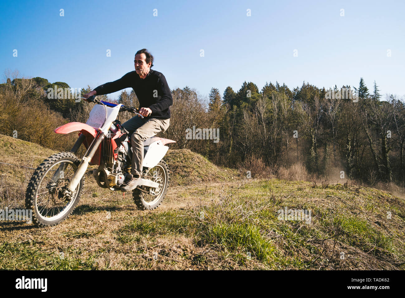 Senior motocross driver riding on circuit Stock Photo - Alamy