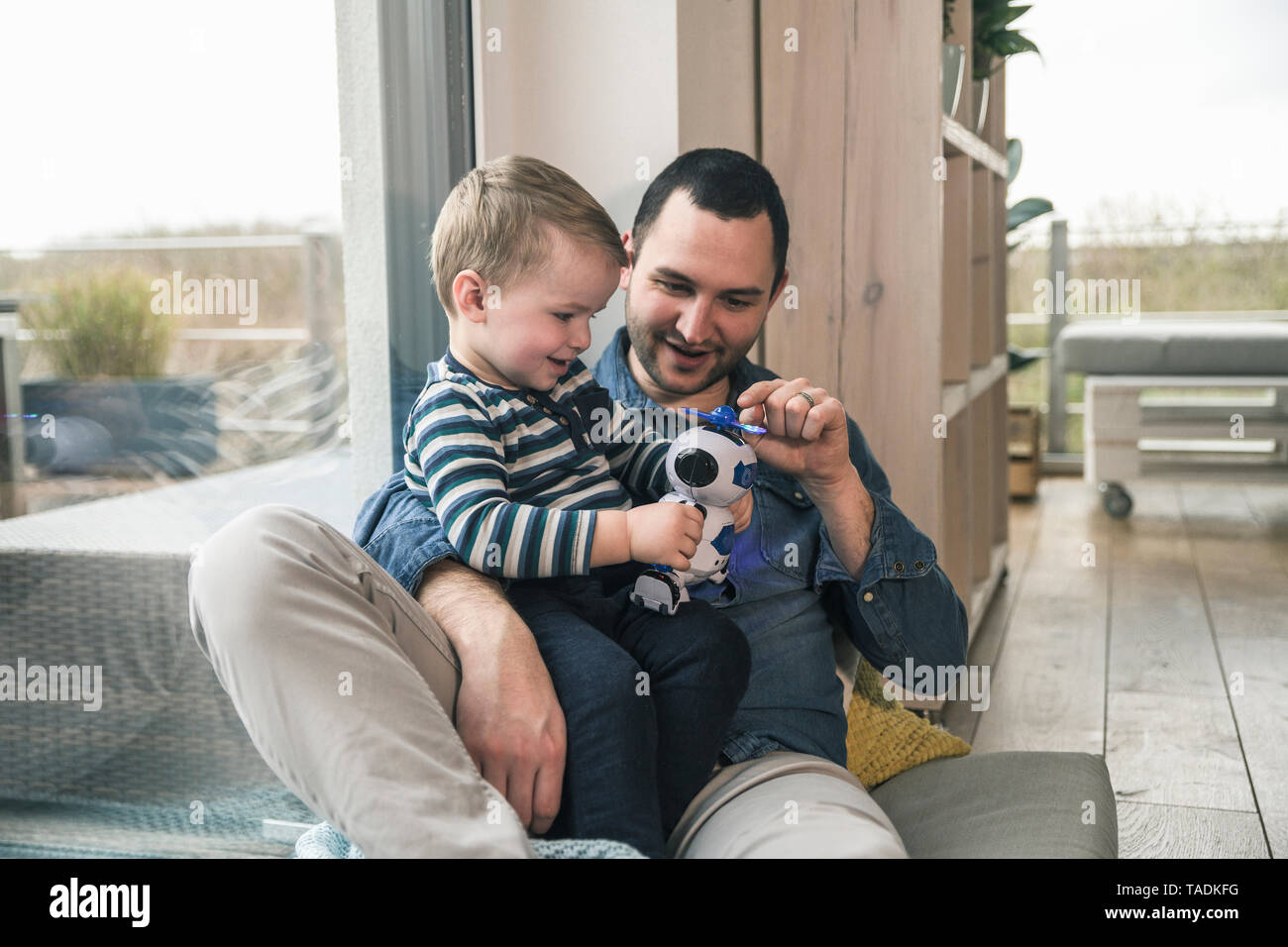 Father and son playing with a toy robot at home Stock Photo - Alamy