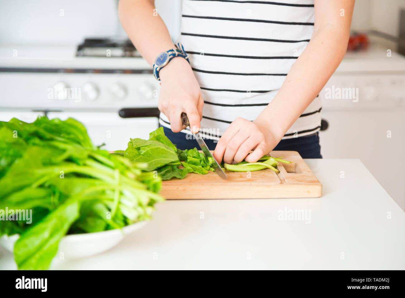 Girl chopping vegetable in the kitchen, partial view Stock Photo - Alamy