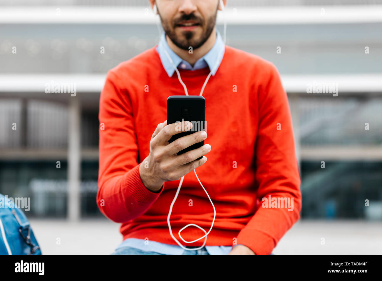 Using his smartohone and earphones hi-res stock photography and images ...
